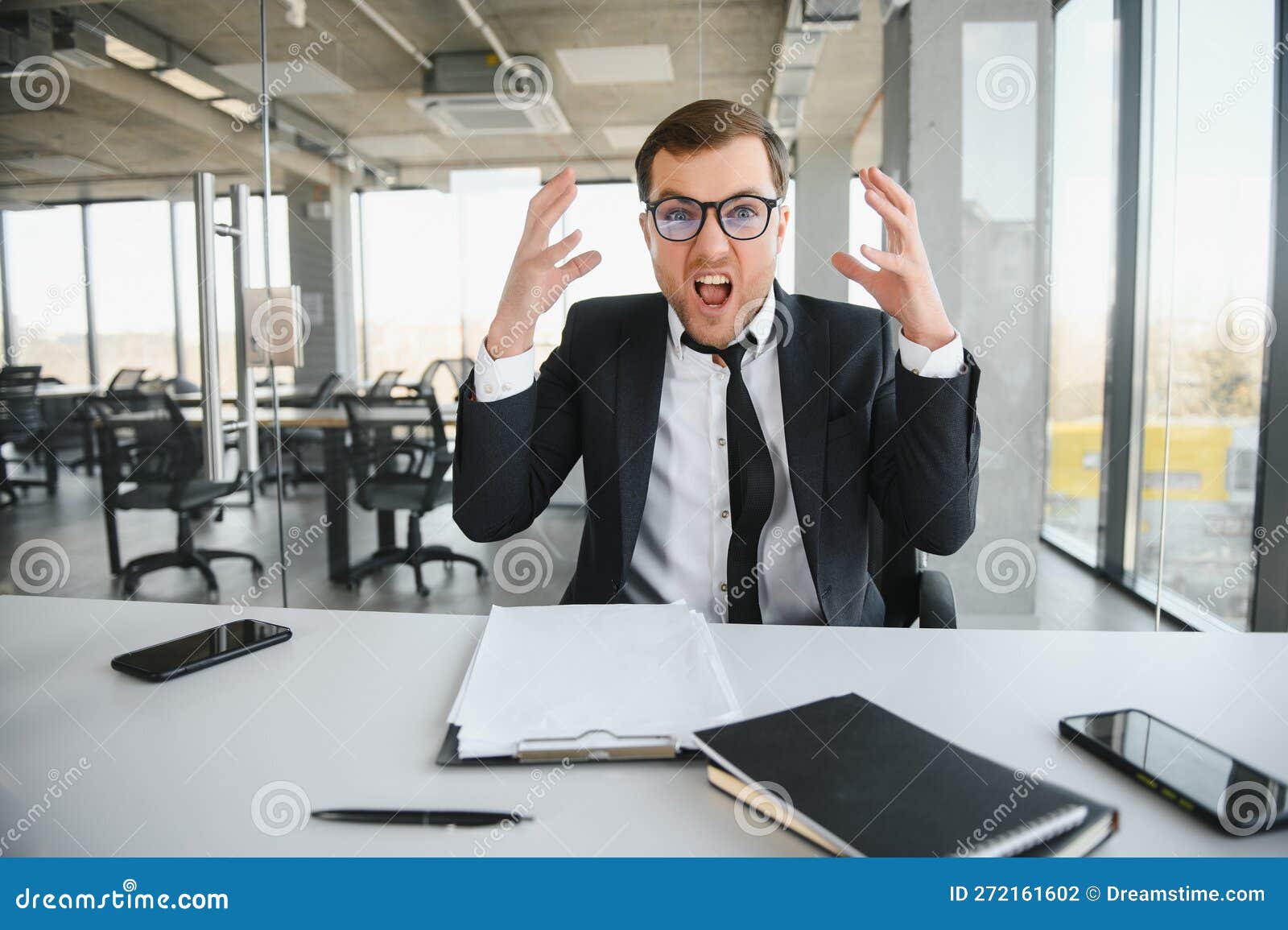 Angry Businessman Sitting at the Table and Screaming. Stock Photo ...
