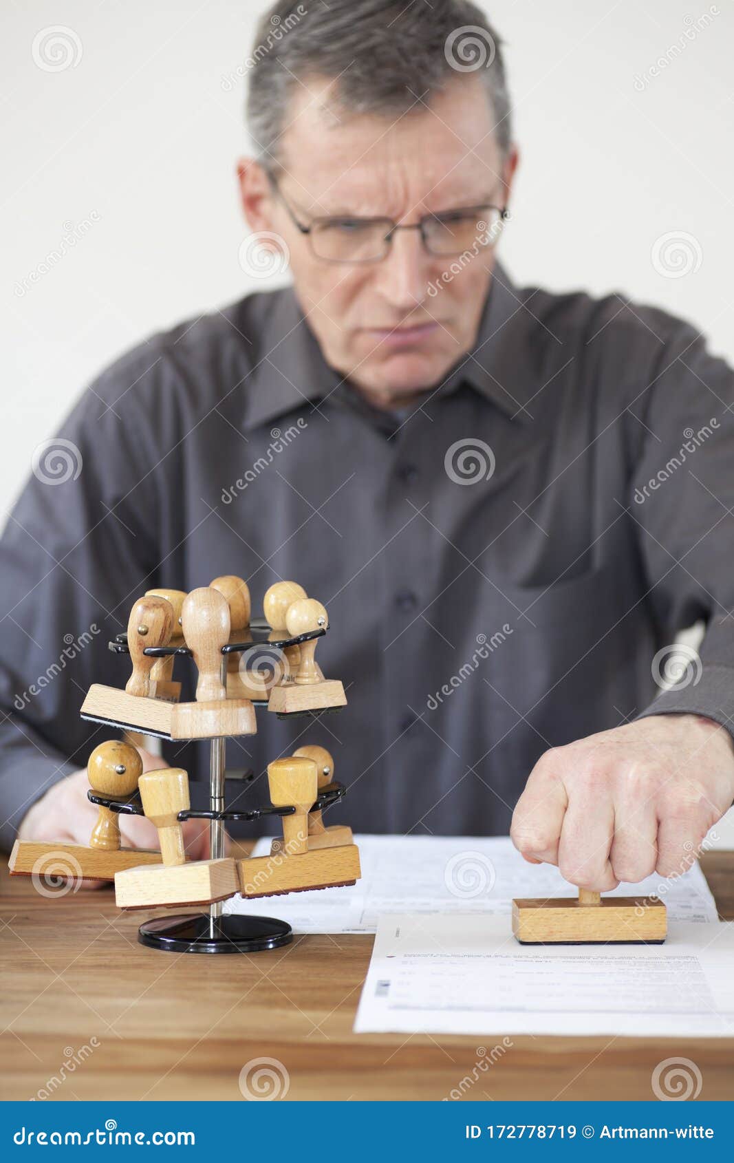 Angry Clerk Stamping a Document at a Desk in an Office Stock Image ...
