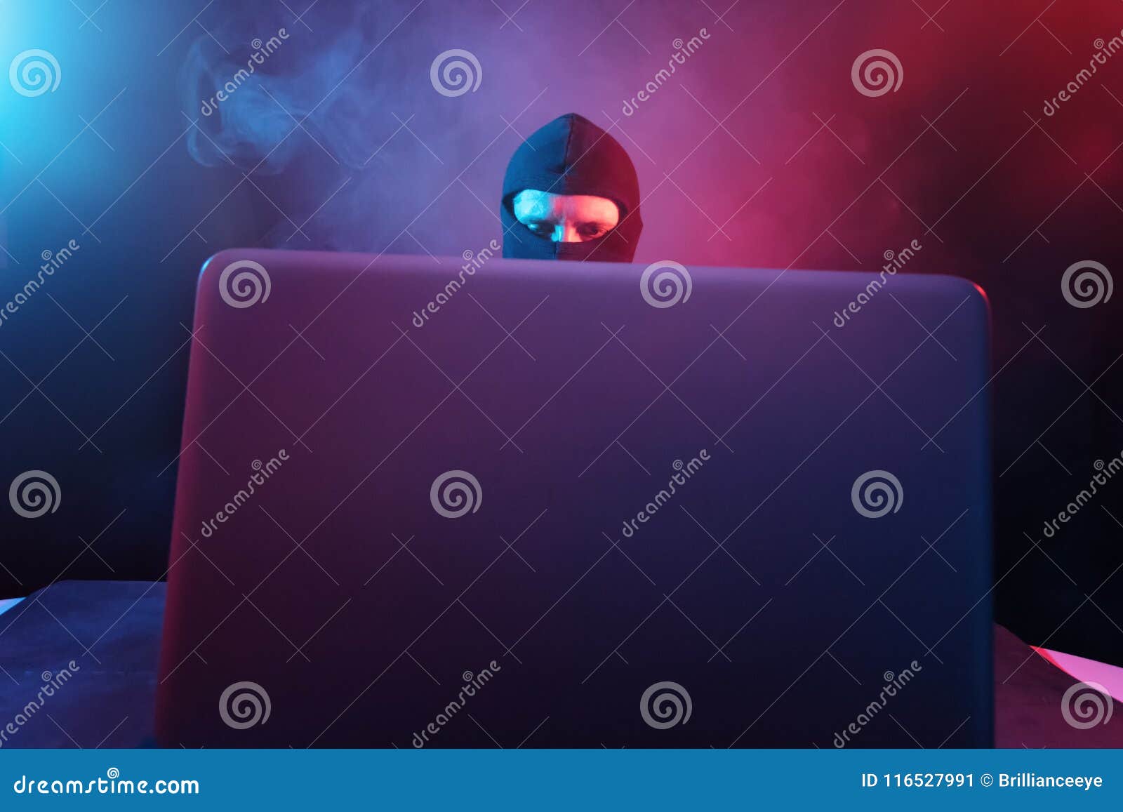 Angry Computer Hacker in Suit Stealing Data from Laptop Illuminated by ...