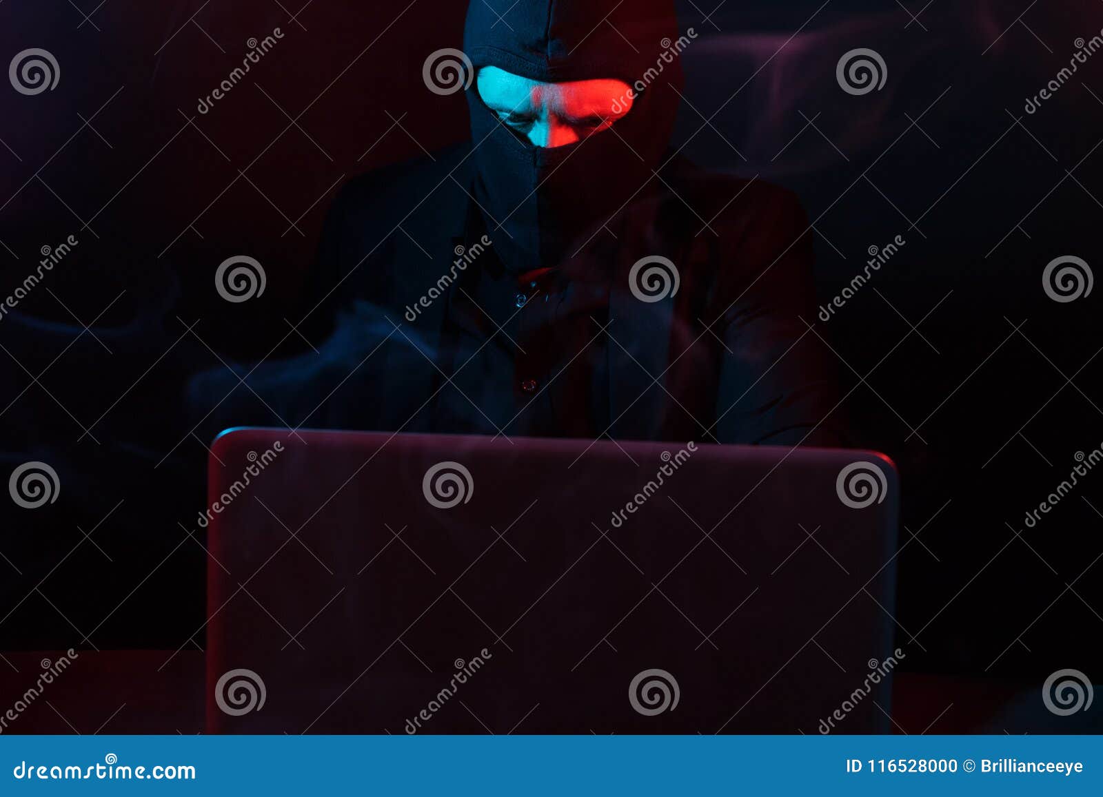 Angry Computer Hacker in Suit Stealing Data from Laptop Illuminated by ...