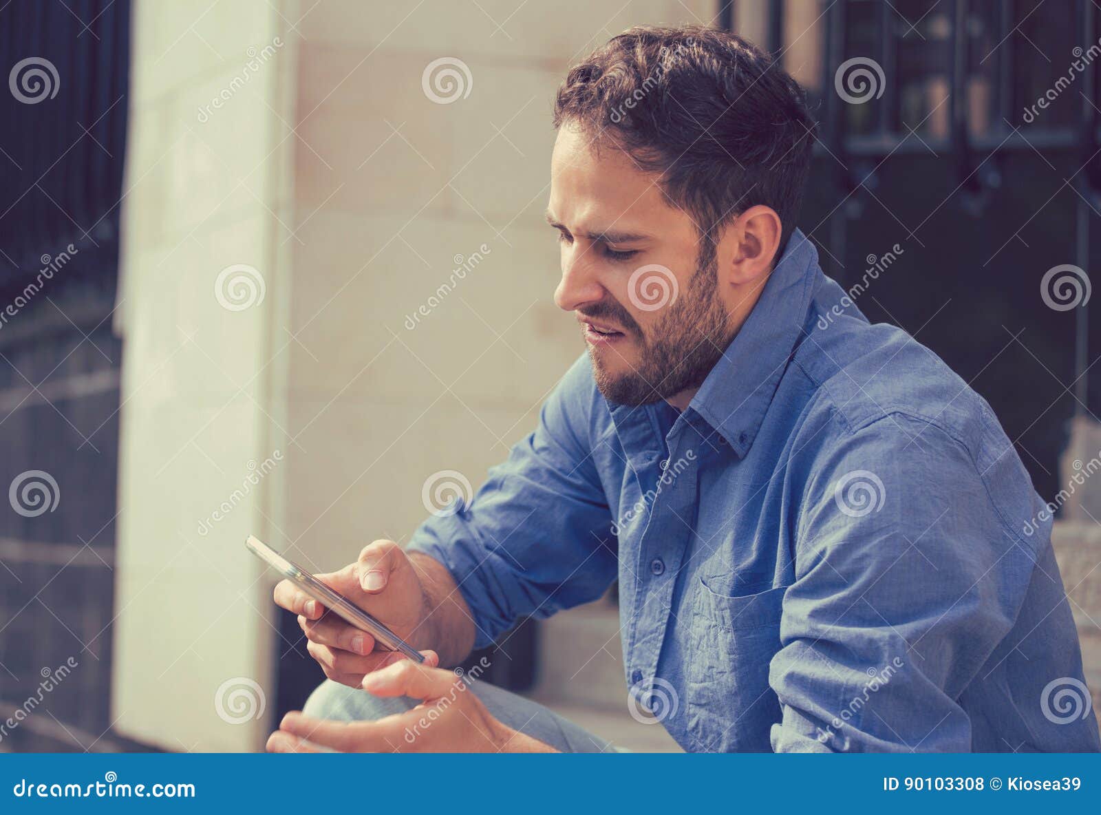 Angry Man Looking at Mobile Phone Sitting on Steps Outside Apartment ...