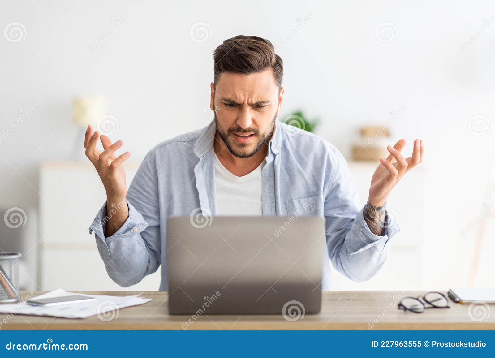Angry Millennial Man Looking at Laptop Screen and Gesturing, Having ...