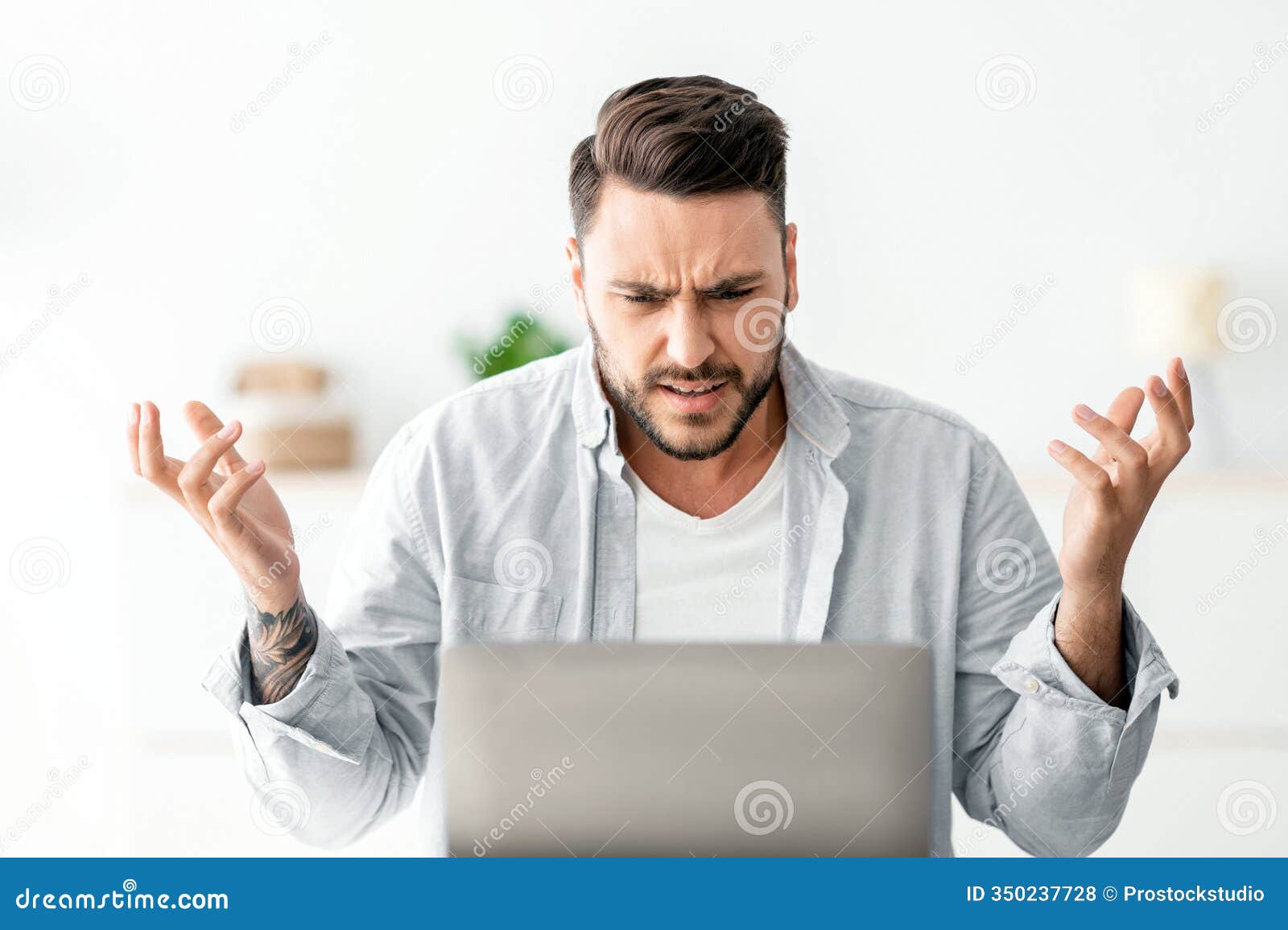 Angry Millennial Man Looking at Laptop Screen and Gesturing, Having ...