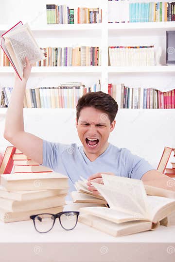 Angry Student Surrounded by Books Throws a Book Stock Photo - Image of ...