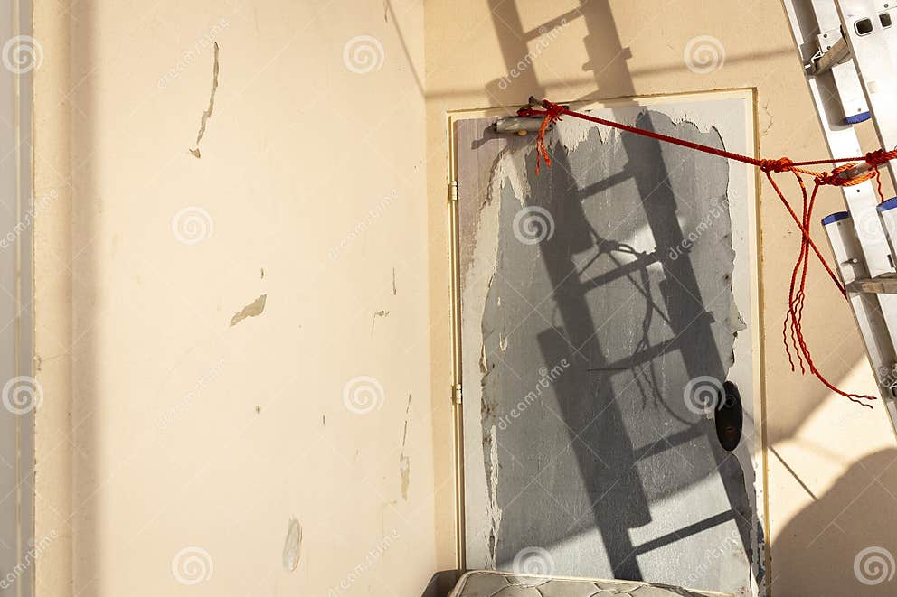 The Angular Shadow of a Collapsible Steel Ladder Stretches Across a ...