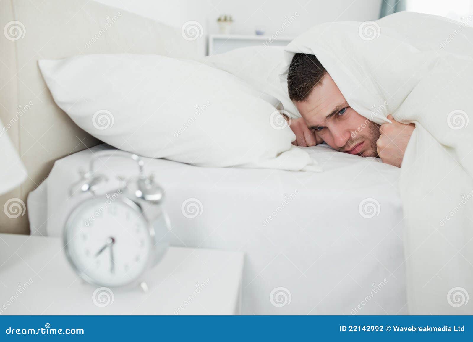Annoyed Man Being Awakened by an Alarm Clock Stock Photo - Image of ...