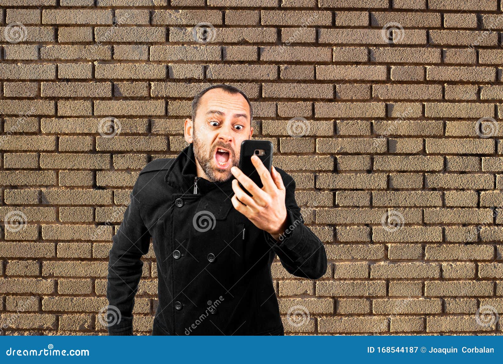 Annoyed Man Shouting at the Mobile Phone Behind a Brick Wall in the ...