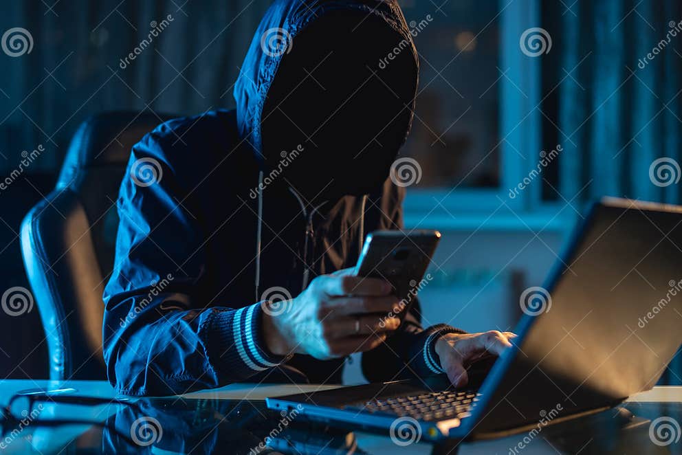 Anonymous Hacker Programmer Uses a Laptop To Hack the System in the Dark. Concept of Cybercrime ...
