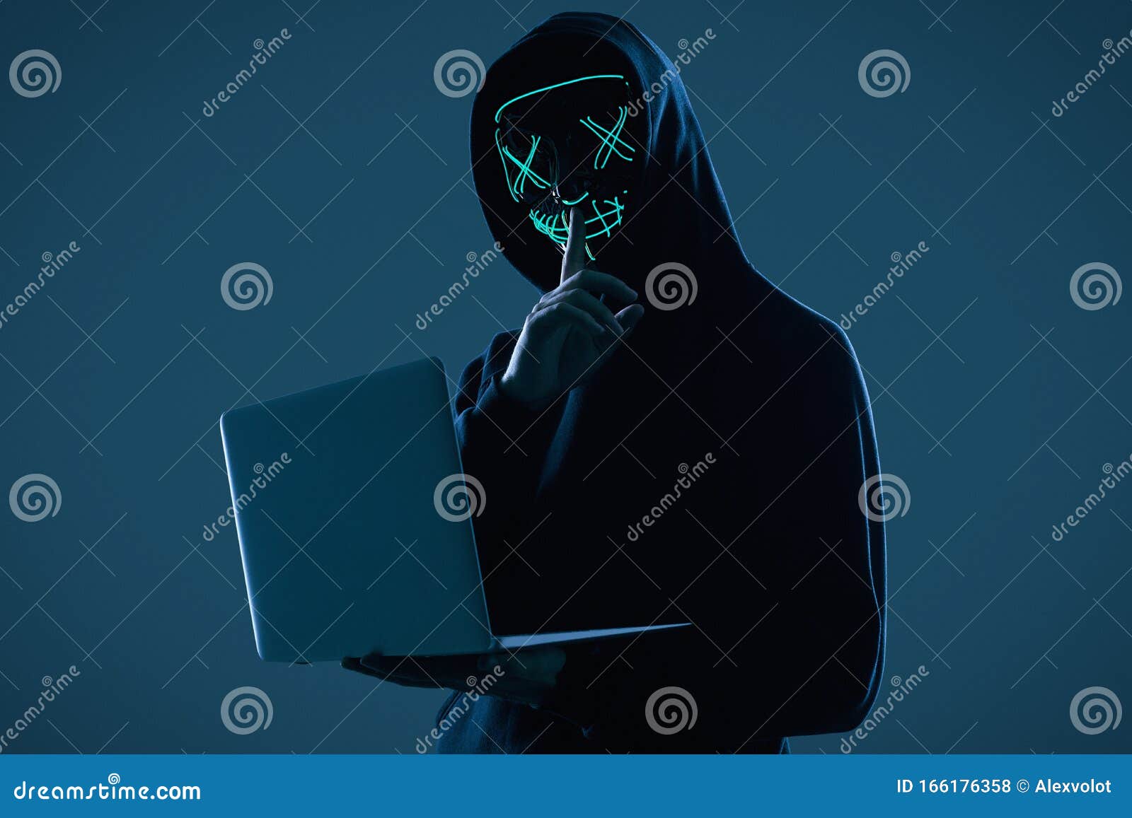 Anonymous Man in a Black Hoodie and Neon Mask Hacking into a Computer ...