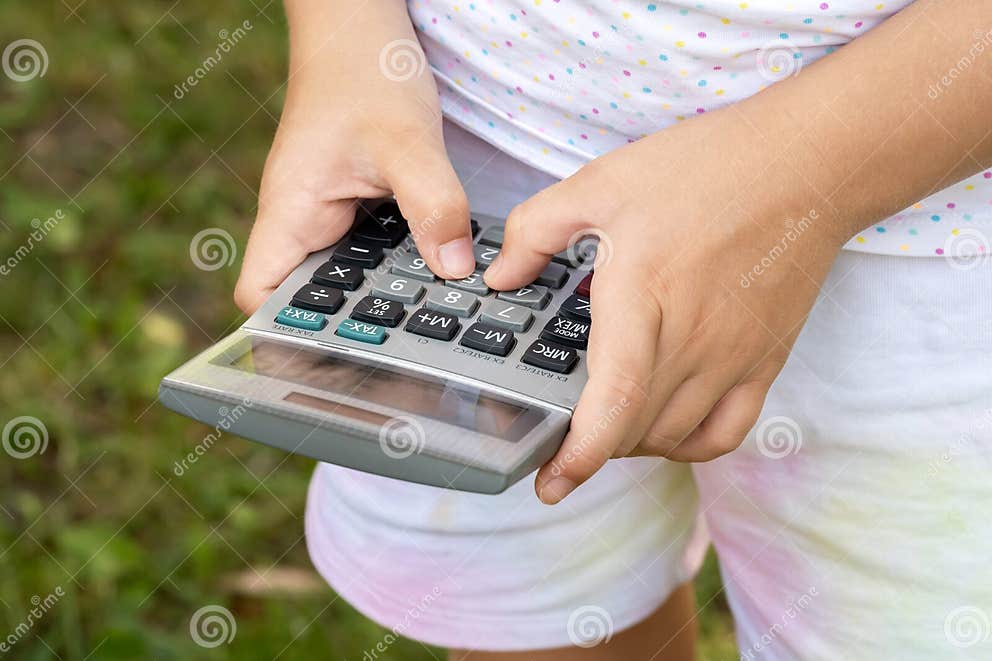 Anonymous Young Girl Child Using a Generic Calculator, Holding it in ...
