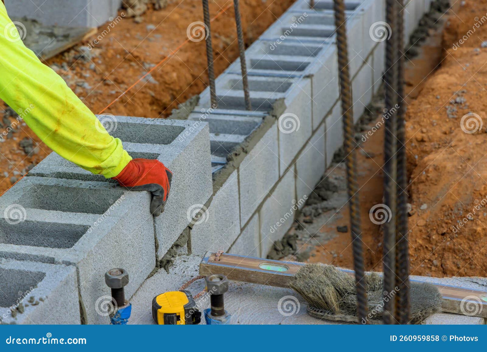 Another Row of Cement Blocks is Being Laid Down by a Bricklayer ...