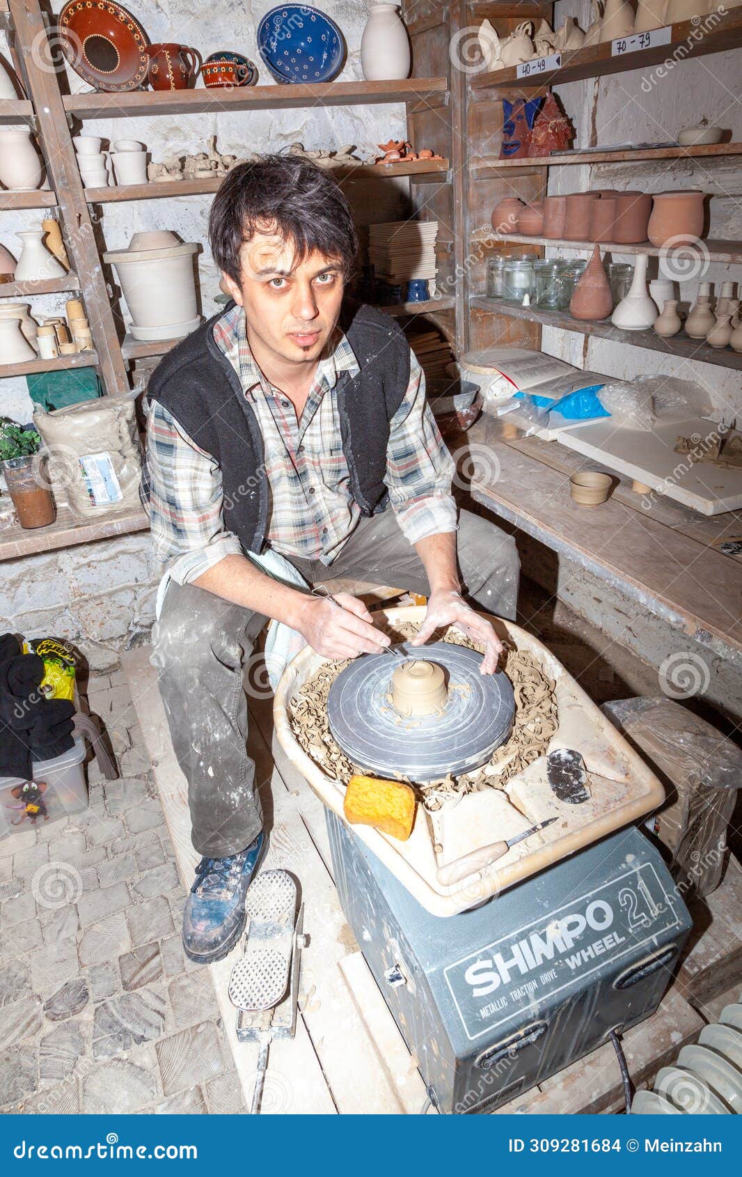 A Potter Demonstrates Pottery Making with a Turn Table and Pottery Clay ...