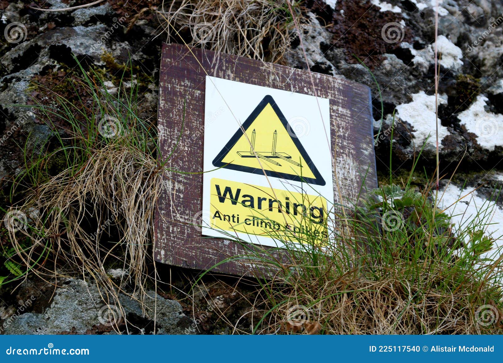 Anti Climbing Spikes Warning Sign on a Stone Castle Wall Stock Photo ...