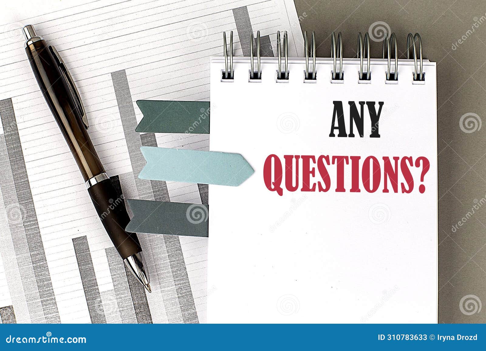 ANY QUESTIONS Text on Notebook with Pen, Calculator and Chart on a Grey ...