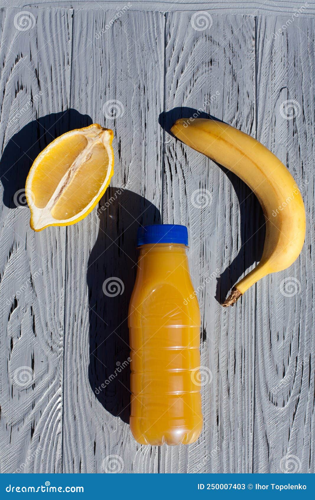 An Appetizing Composition of a Bottle of Orange Juice, Half a Lemon and ...