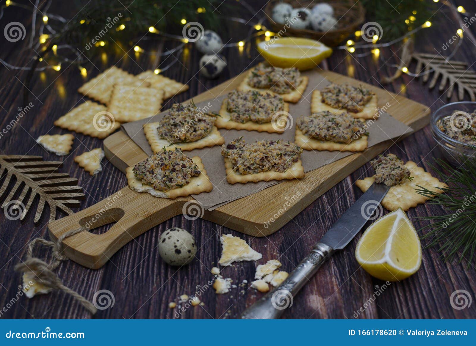 Appetizing Crackers with Paste on a Cutting Board, Lemon Slices and a ...