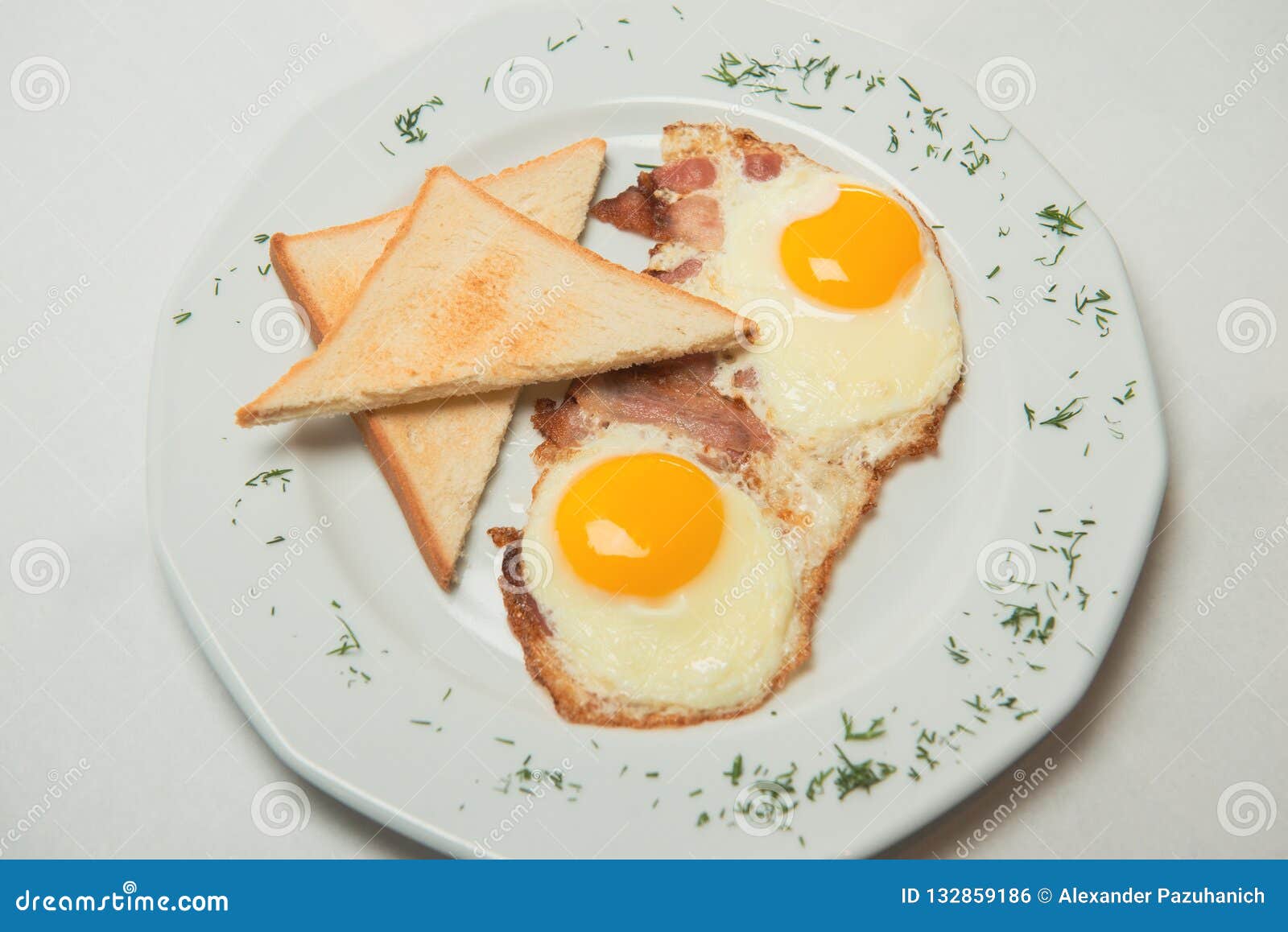 Appetizing Fried Eggs on White Plate with Toasts and Bacon Decorated ...