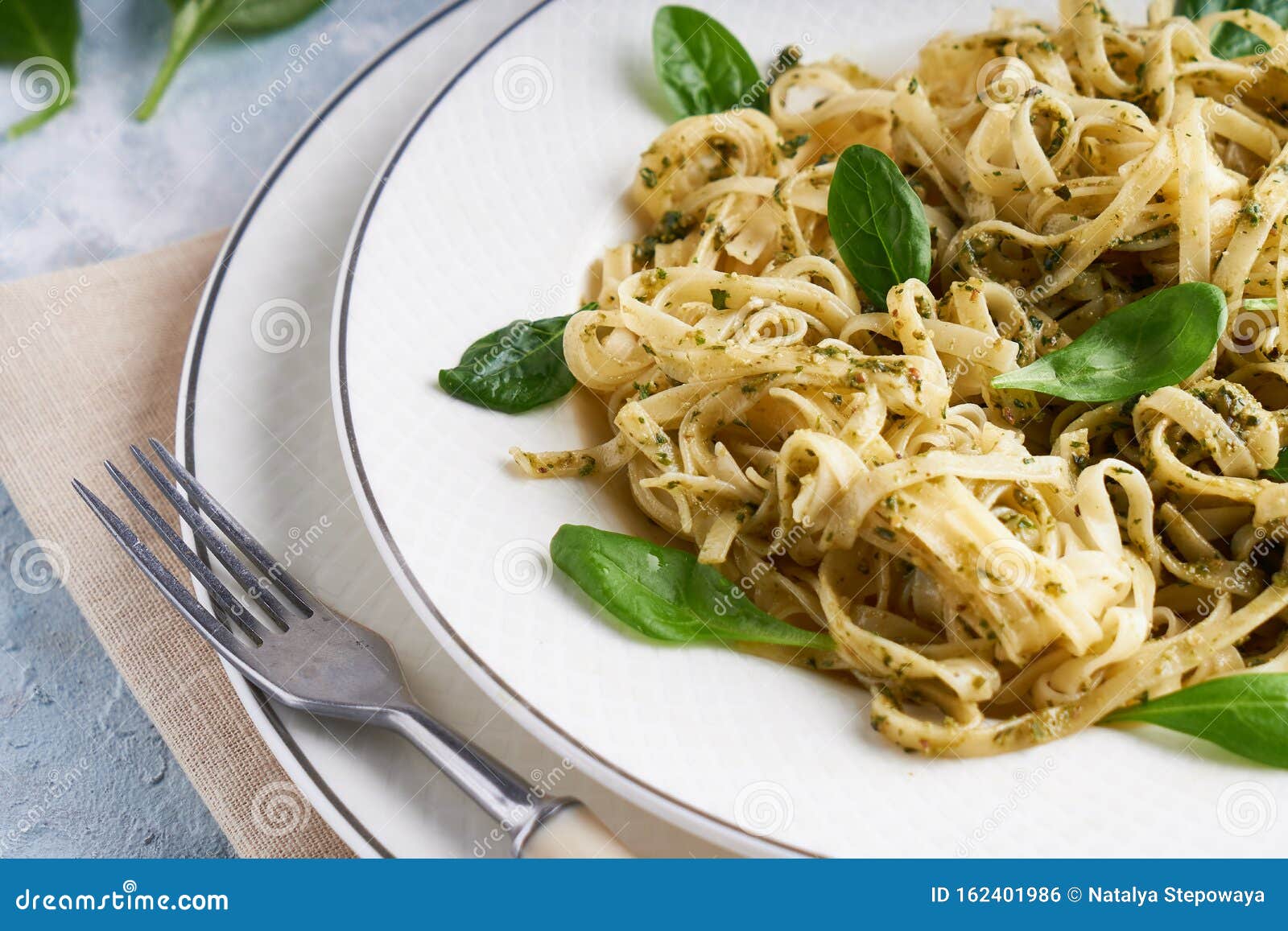 Appetizing Pasta with Sauce Pesto and Spinach in Plate on Light Blue ...