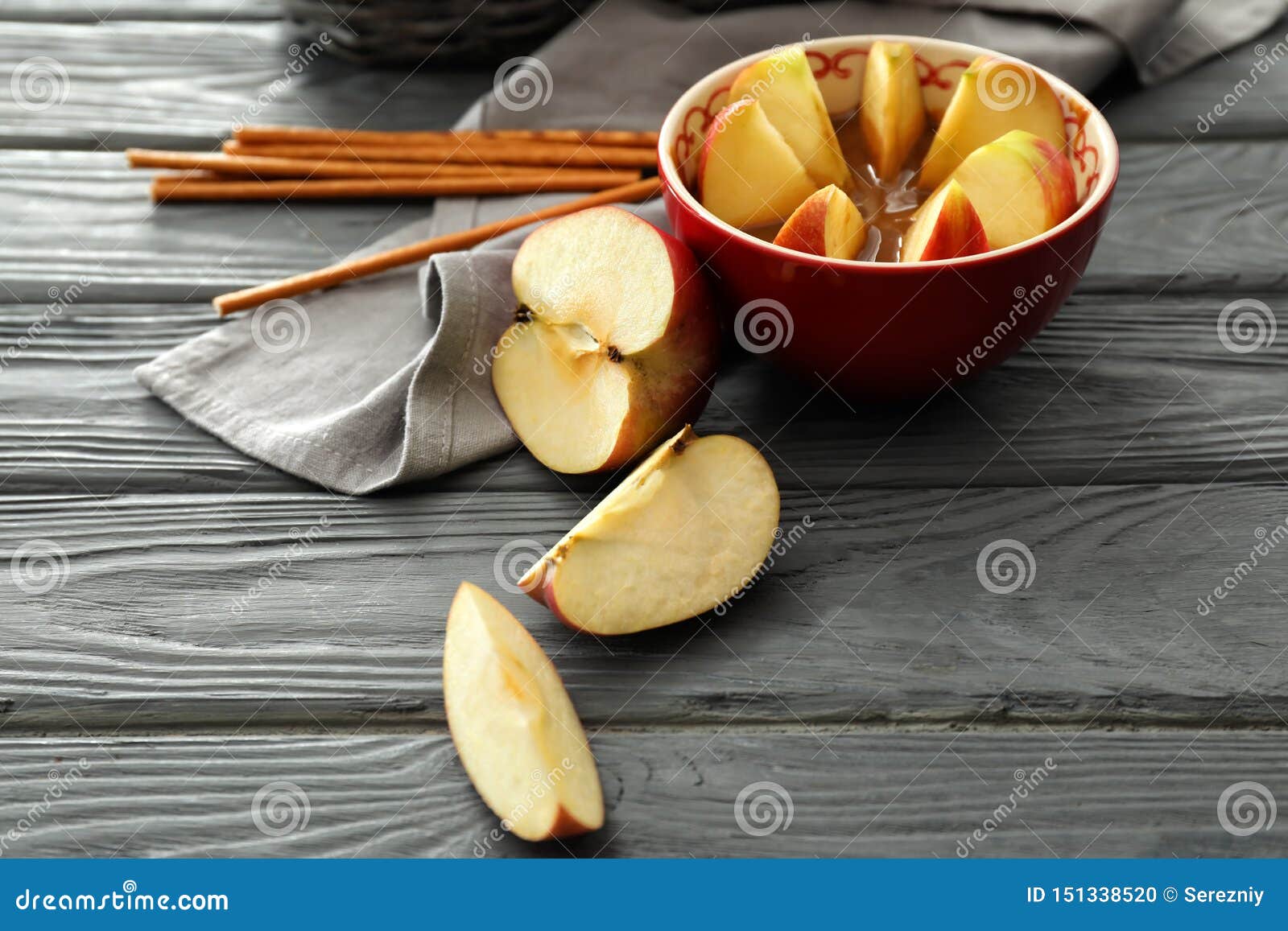 Apple Wedges in Bowl with Sauce on Wooden Table Stock Photo - Image of ...