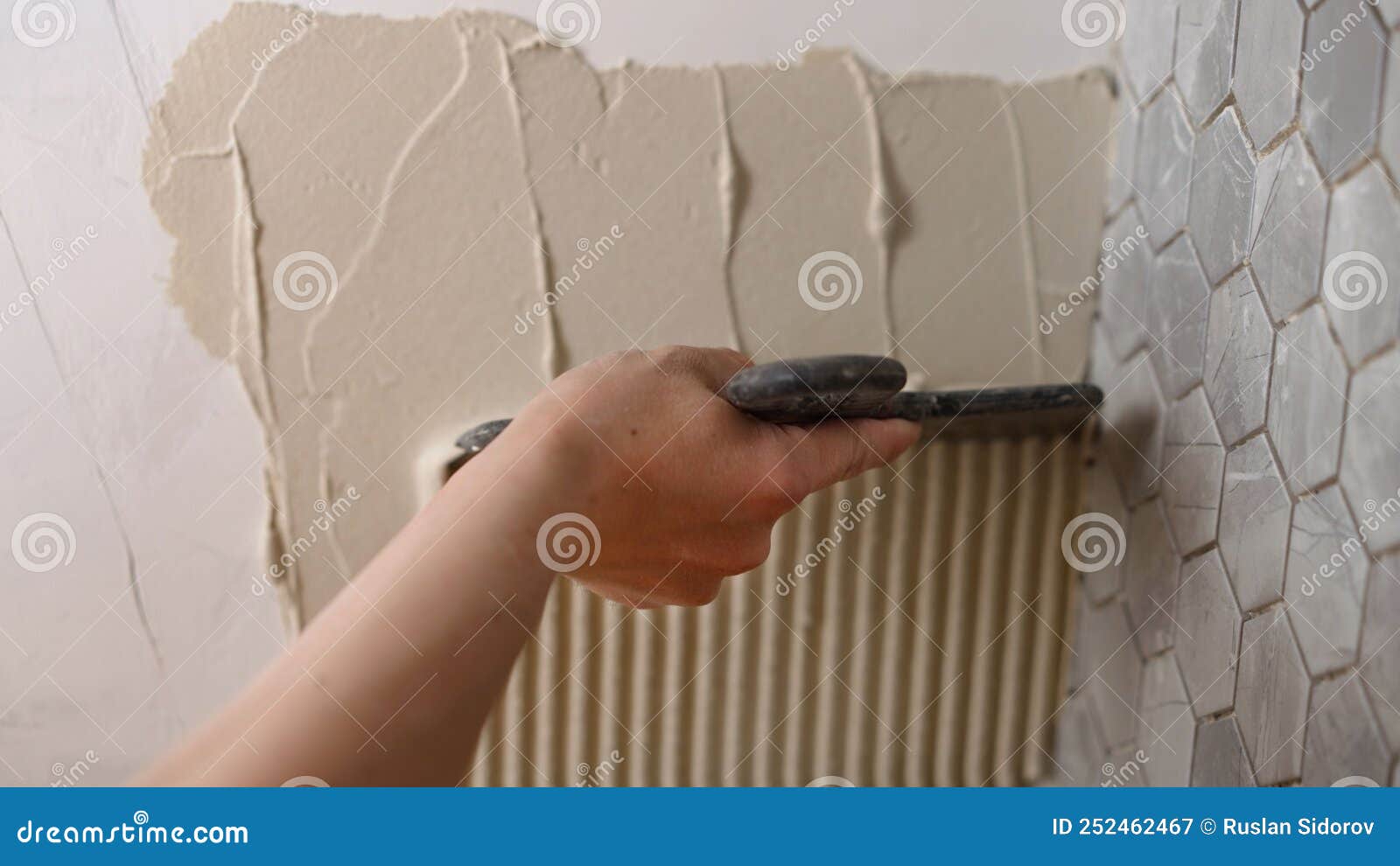 Applying Adhesive for Ceramic Tiles on the Wall. a Worker Using a ...