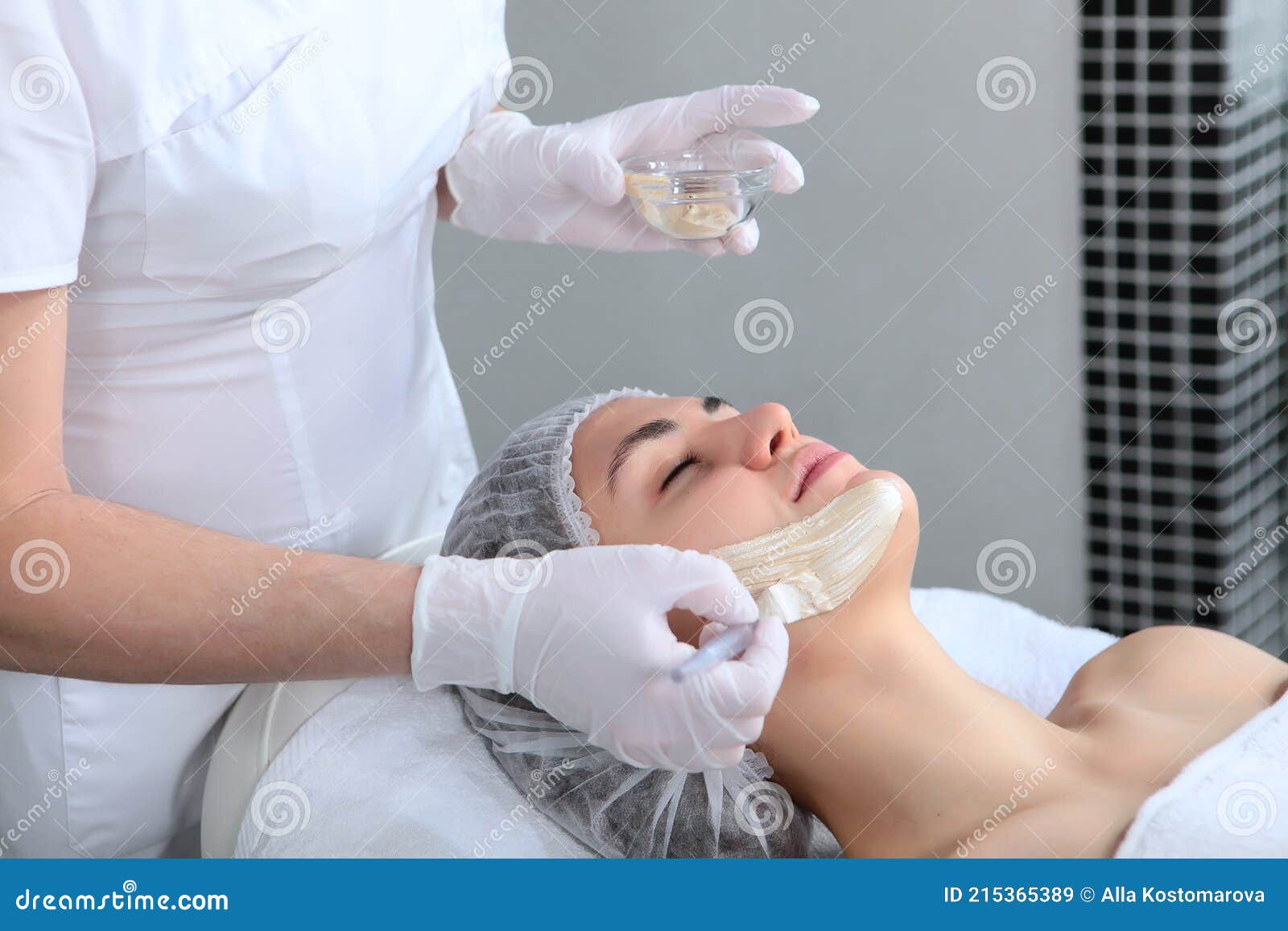 Applying A Mask To The Face Of A Young Woman In A Cosmetology Clinic