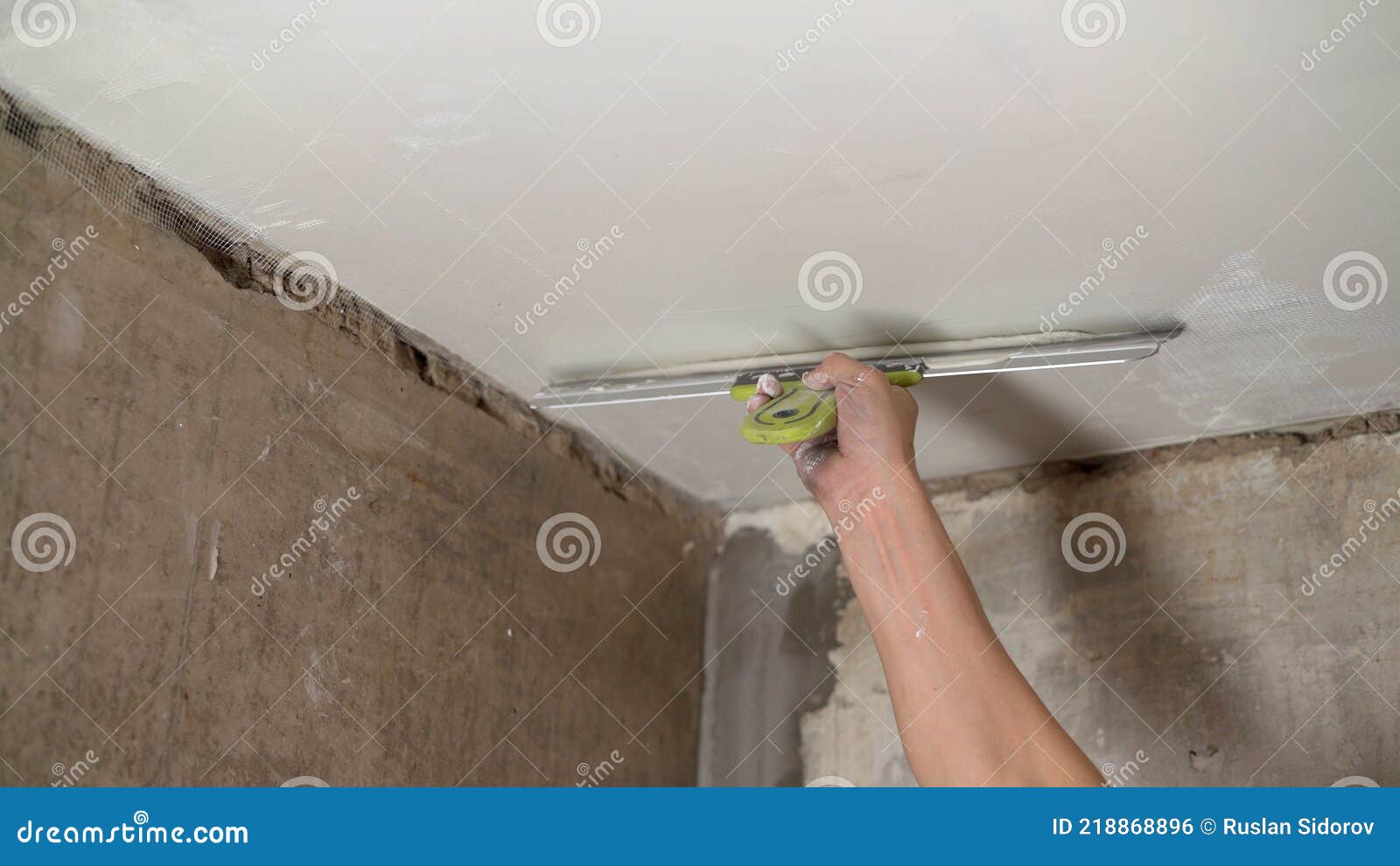 A Man Puts Putty on the Ceiling during Renovation Work. Hand with a ...