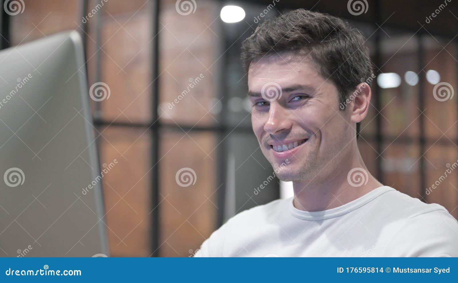Appreciating Young Man Looking at Camera at Work Stock Photo - Image of ...