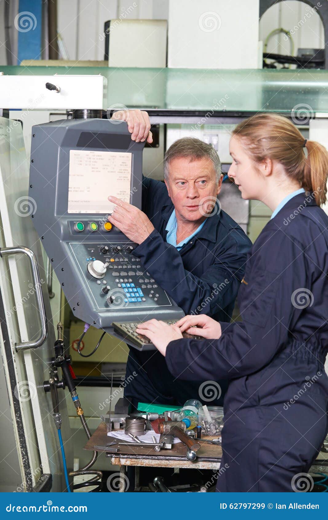 Apprentice and Engineer Using Computer Controlled Cutting Machin Stock ...