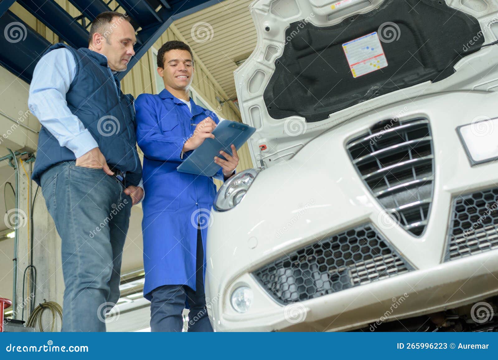 Apprentice Mechanic Inspecting Car Under Supervision Stock Image ...