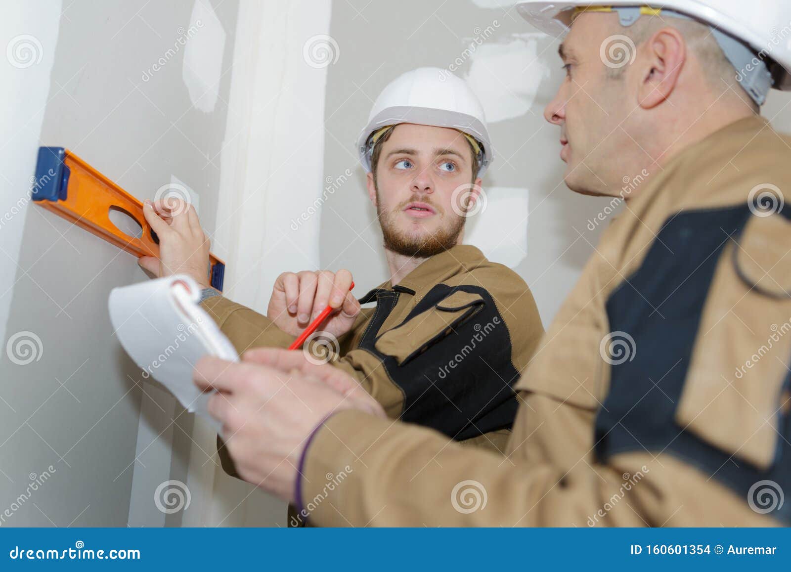 Apprentice with Supervisor Using Spirit Level Stock Photo - Image of ...