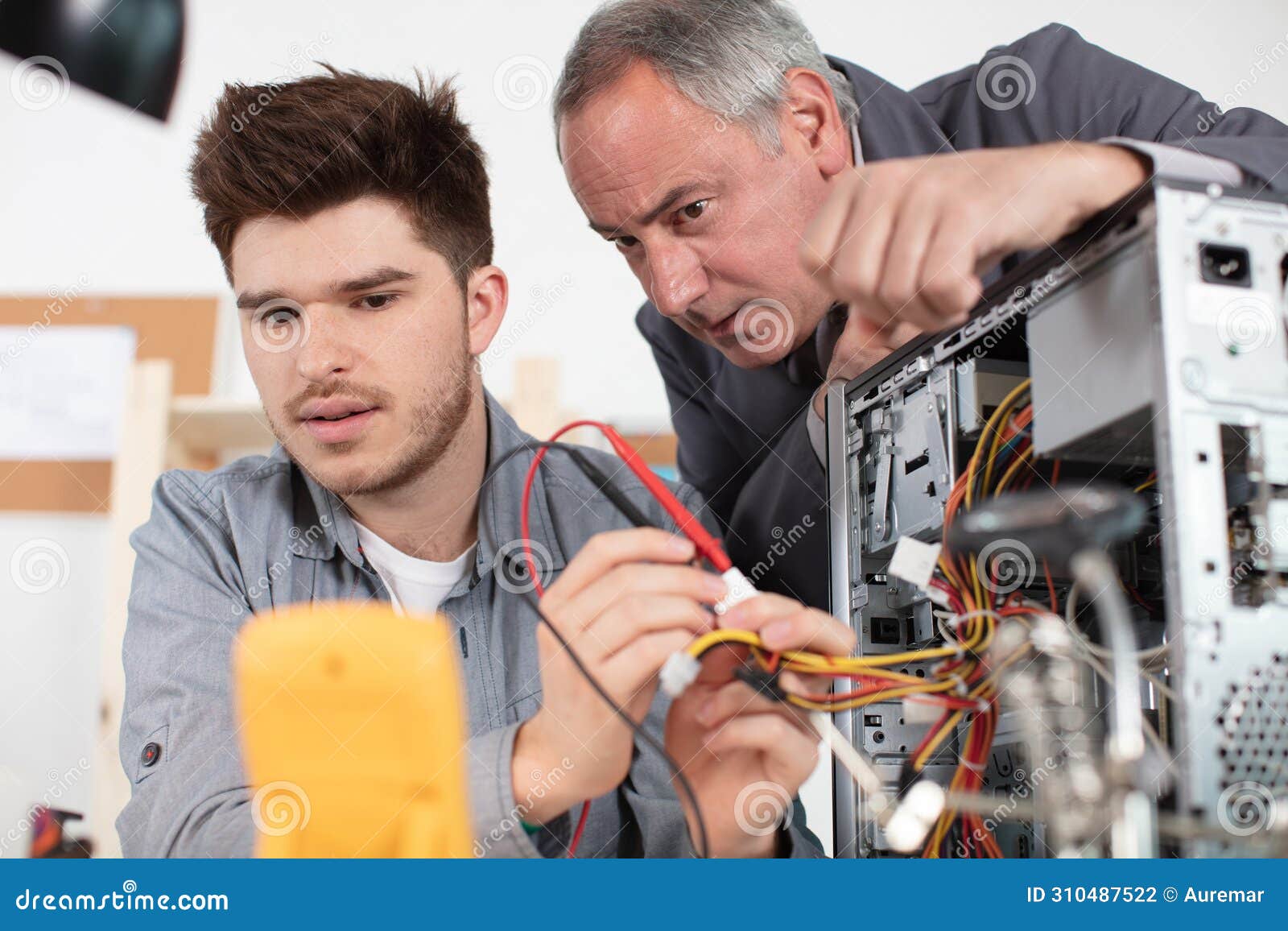 Apprentice Under Supervision Testing Computer with Multimeter Stock ...