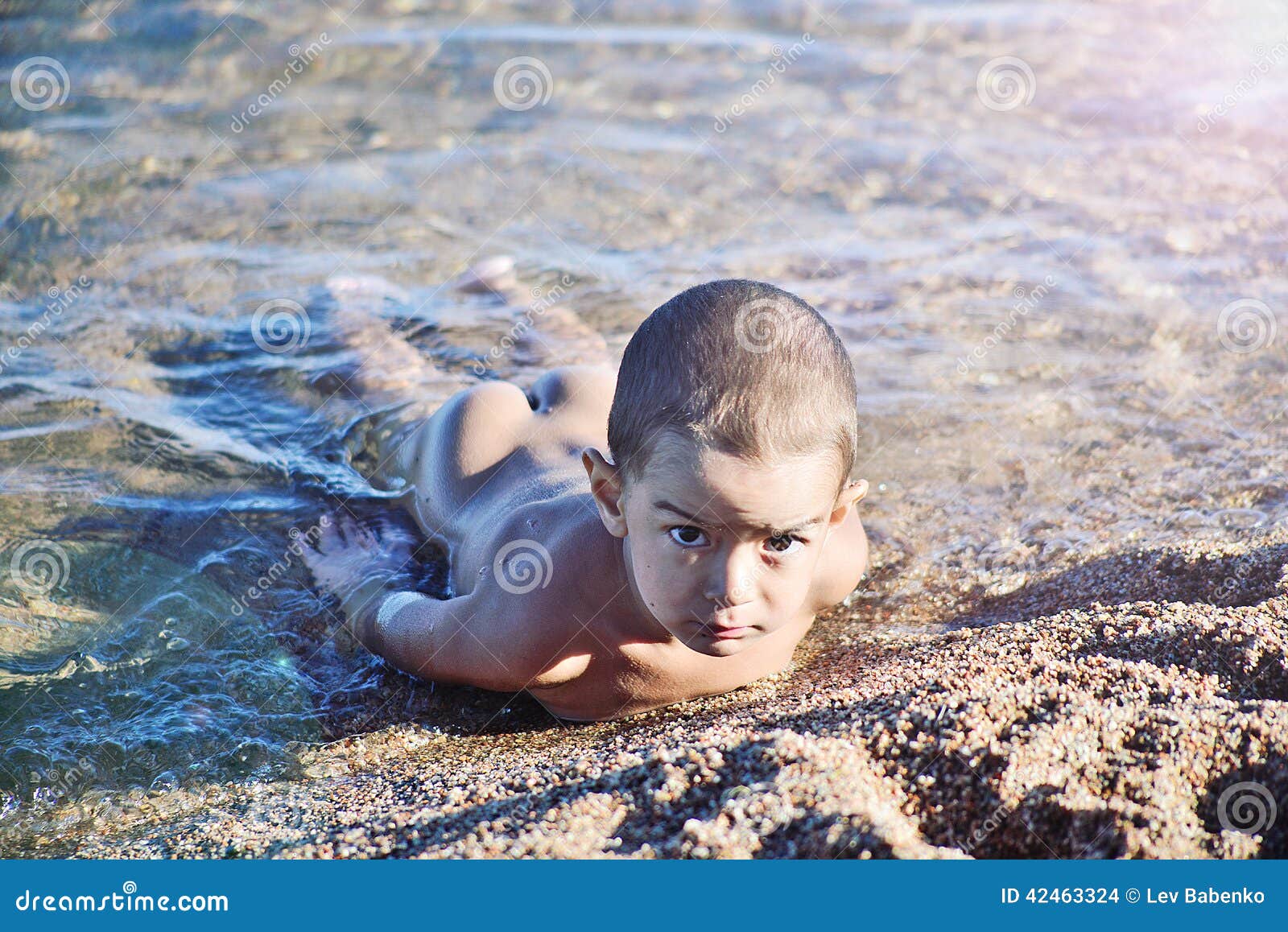 Boy Lying On The Beach In The Water Stock Photo - Image: 42463324