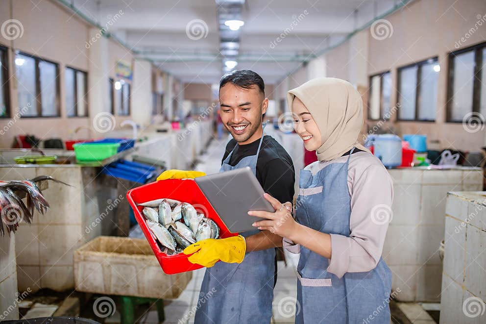 Aquaculture Workers Engaging in Collaborative Efforts at a Fish ...