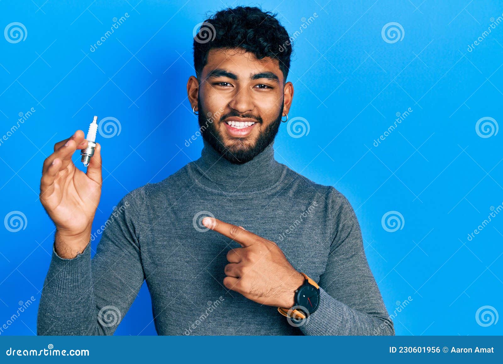 Arab Man with Beard Holding Spark Plug Smiling Happy Pointing with Hand ...