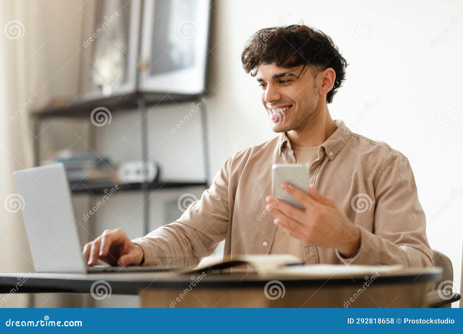 Arab Man Texting on Cellphone Working at Laptop in Office Stock Photo ...