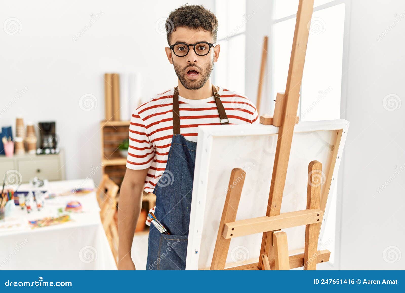 Arab Young Man at Art Studio in Shock Face, Looking Skeptical and ...