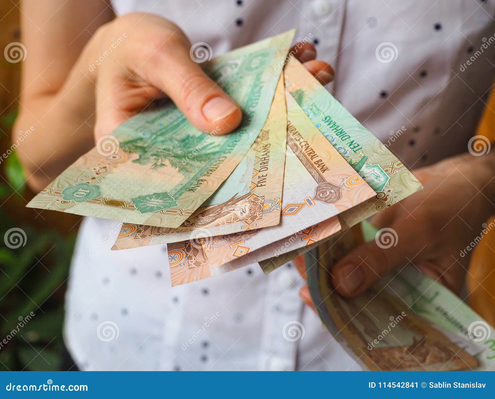 Arabic Coins of Dirhams. Curled Banknotes in His Hands. Stock Image ...