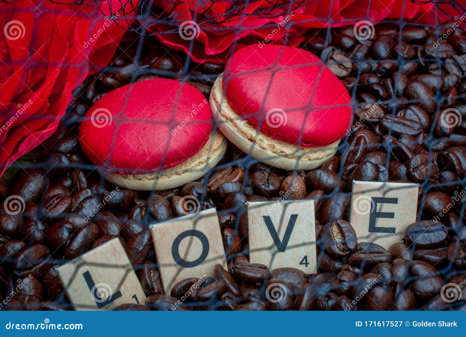 Red Macaroon On Rosted Coffee Beans Background With Red Flowers And