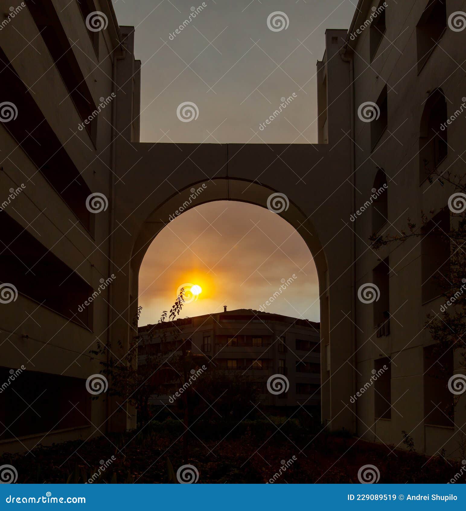 Arch between Buildings on the Background of Sunset. Stock Image - Image ...