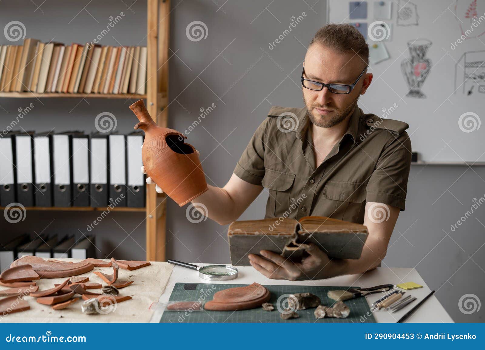 Archaeologist Working in an Office Reading an Old Book Studying an ...