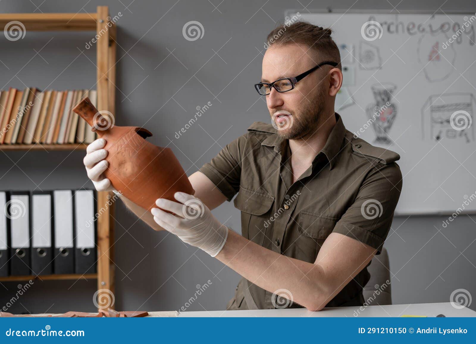 Archaeologist Working in an Office Studying an Ancient Vessel while ...