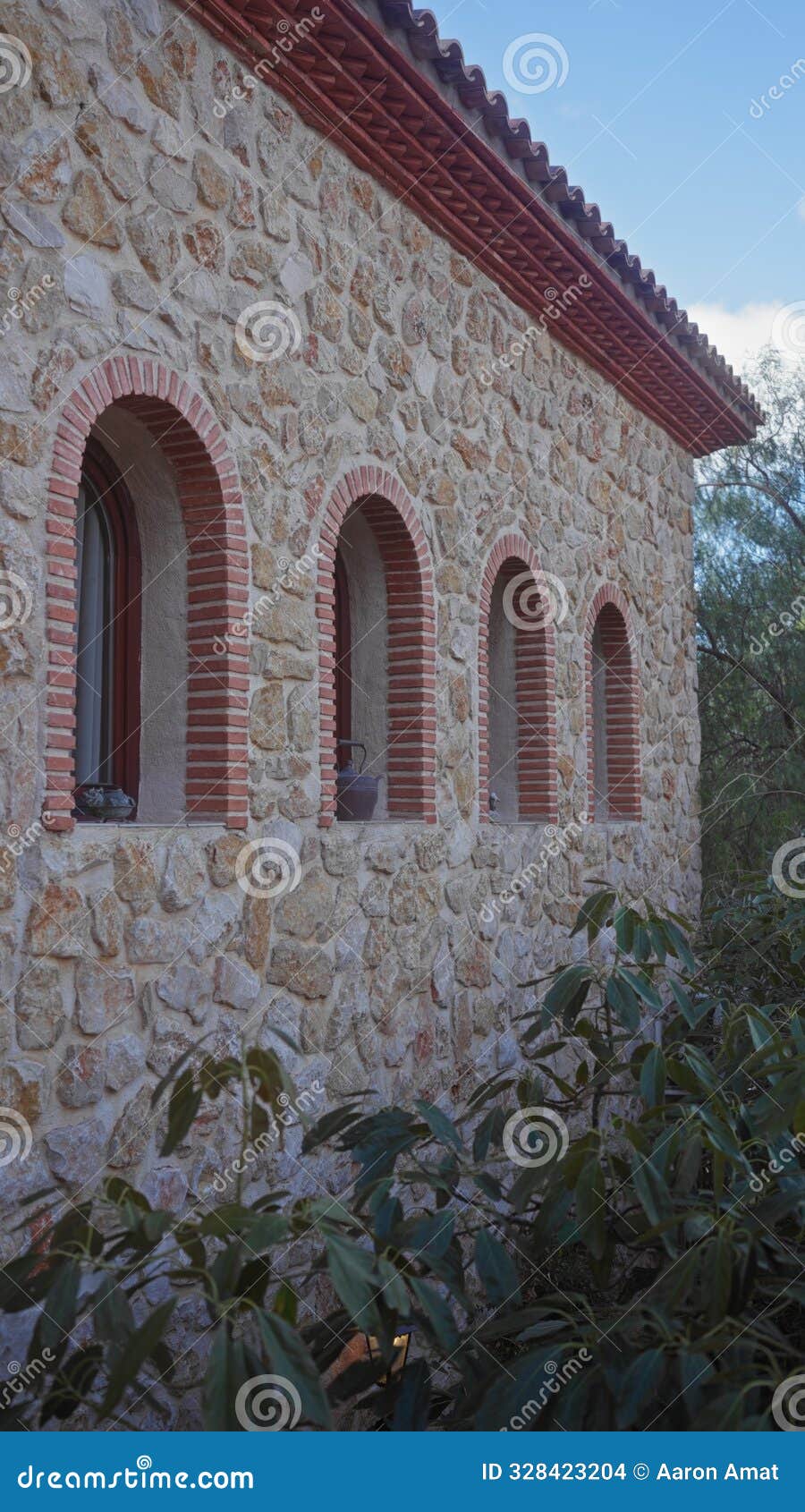 An Archaic Stone Building Featuring Arched Windows, Red Tile Roof, and ...
