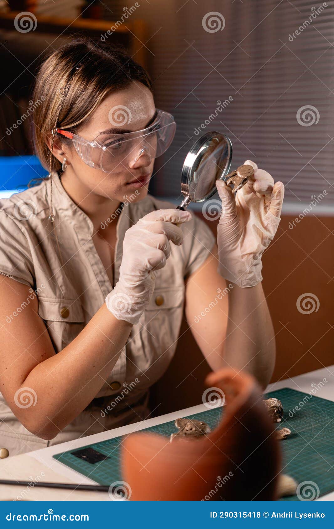 Archeologist Looking through Magnifying Glass on Artifacts, Working ...