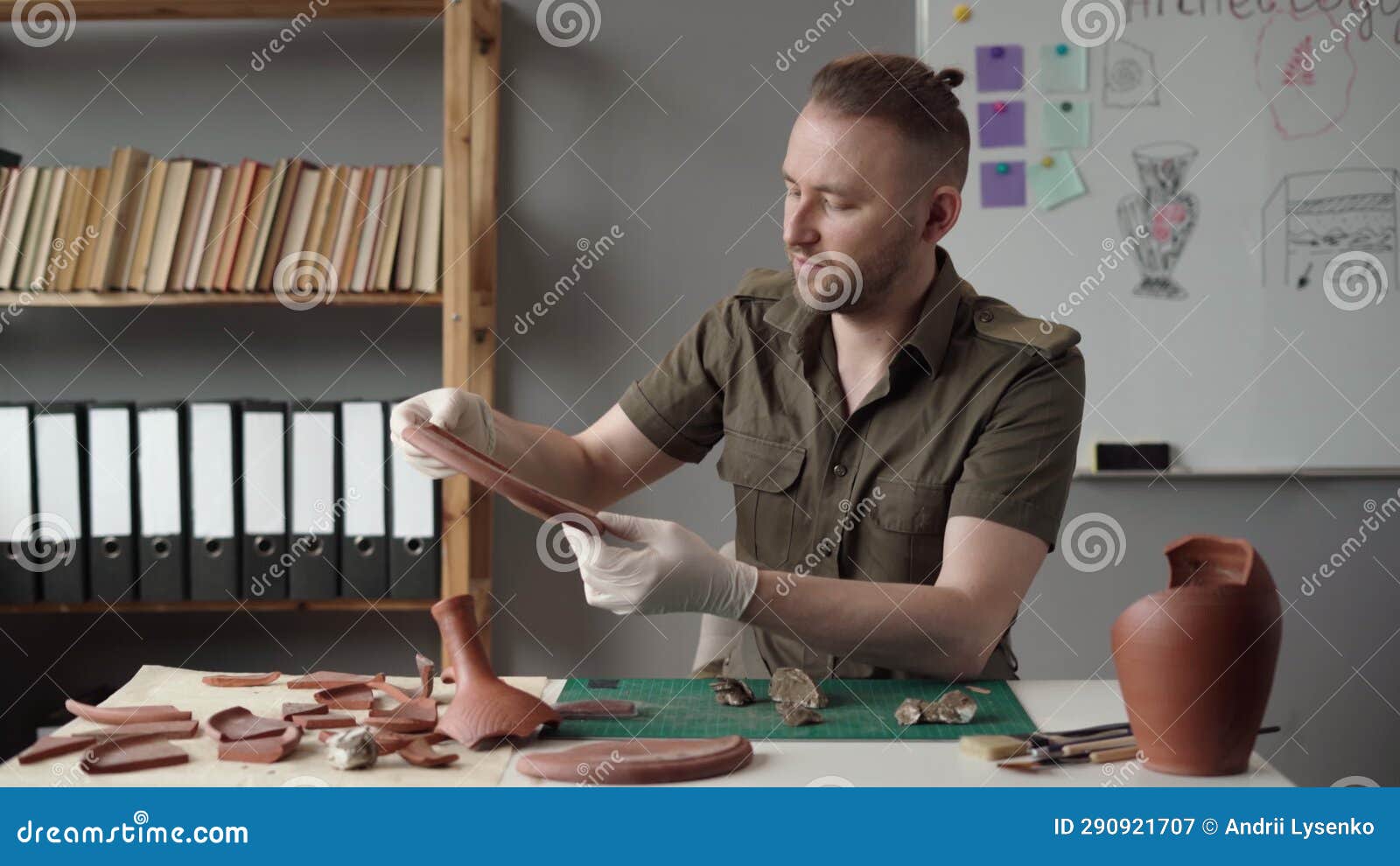 Archeologist Working in the Office, Studying an Ancient Clay Artifacts ...