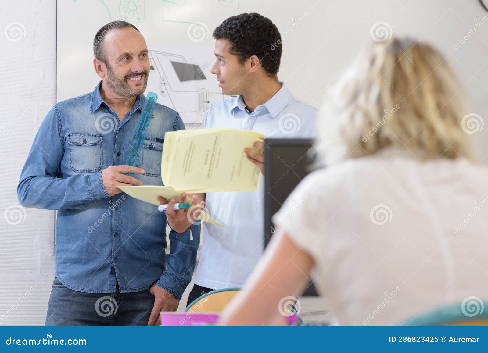 Architect with Apprentice Looking at Papers in Office Stock Image ...