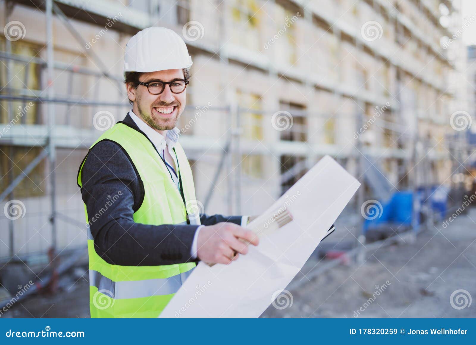 An Architect / Civil Engineer at Work on a Construction Site, Holding ...