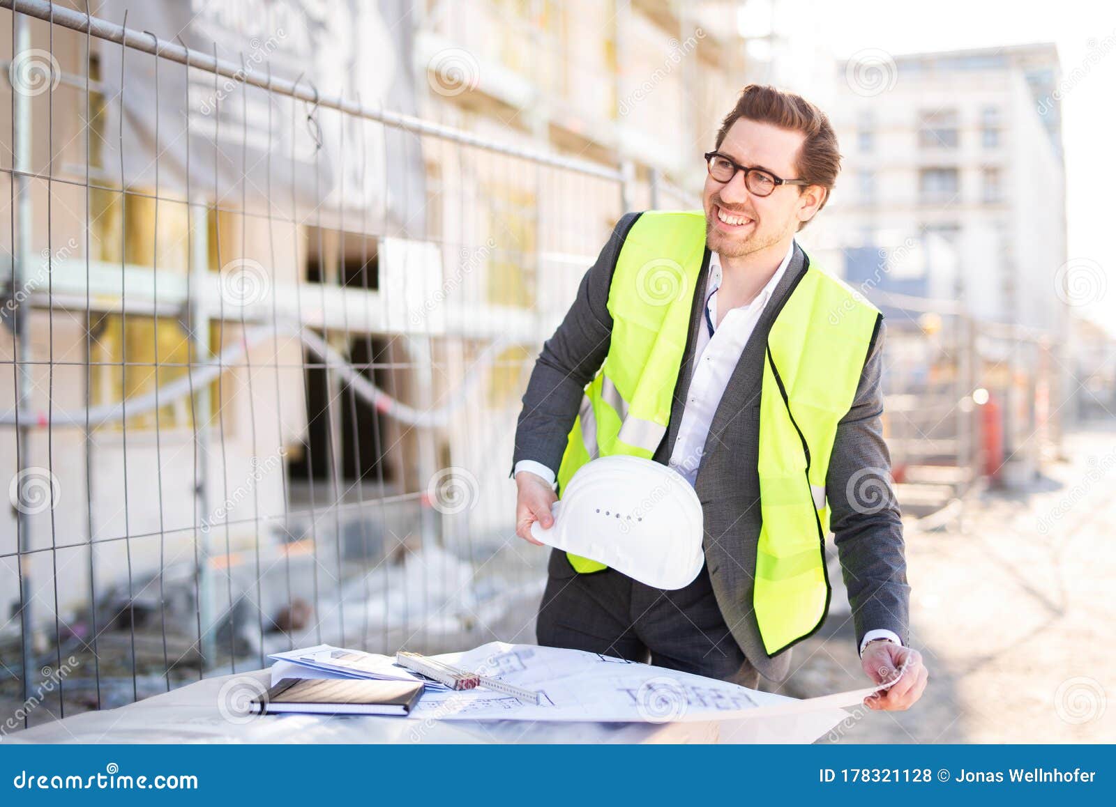 An Architect / Civil Engineer at Work on a Construction Site, Holding ...