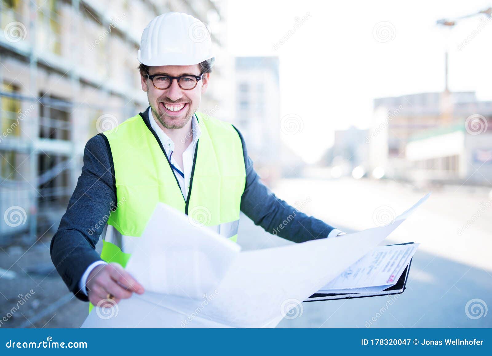 An Architect / Civil Engineer at Work on a Construction Site, Holding ...