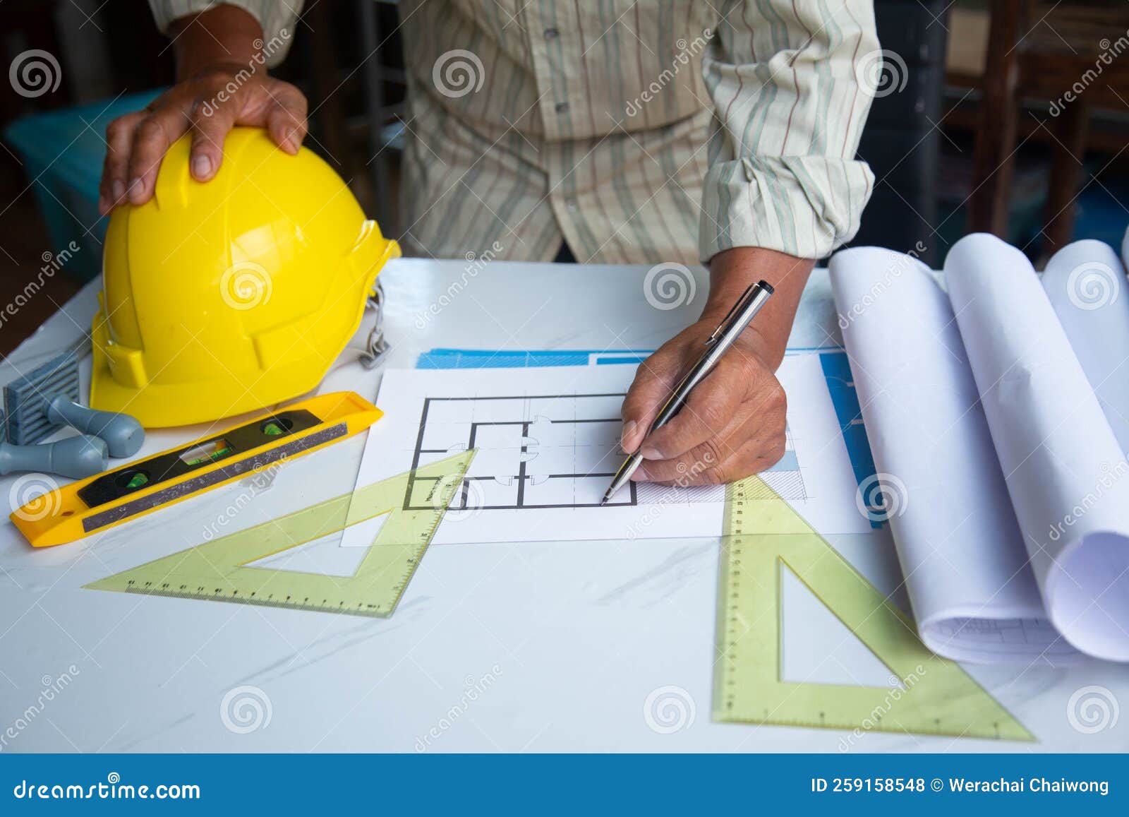 Architect Designing Project at Construction Site with Blueprint Stock ...
