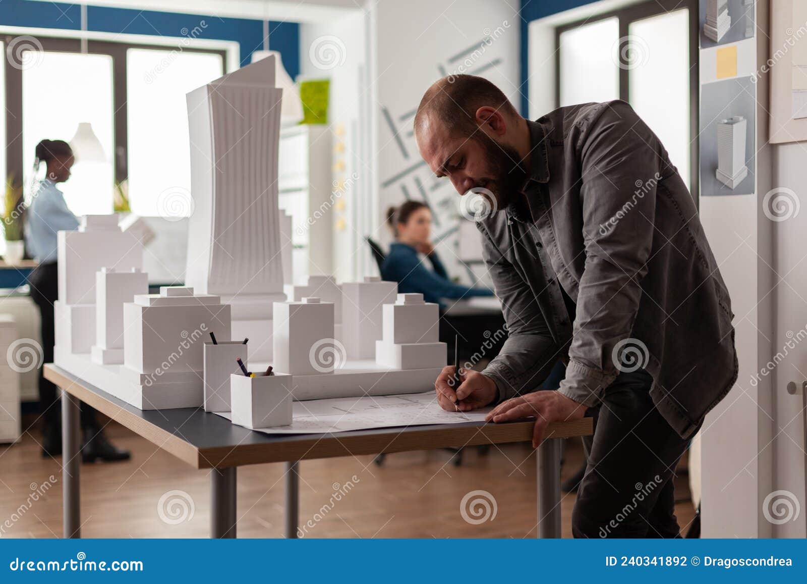 Architect Drawing Blueprints at Desk in Modern Architectural Office ...